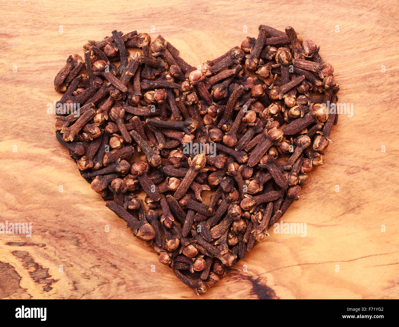 Heart form made from spice cloves on wooden background Stock Photo - Alamy