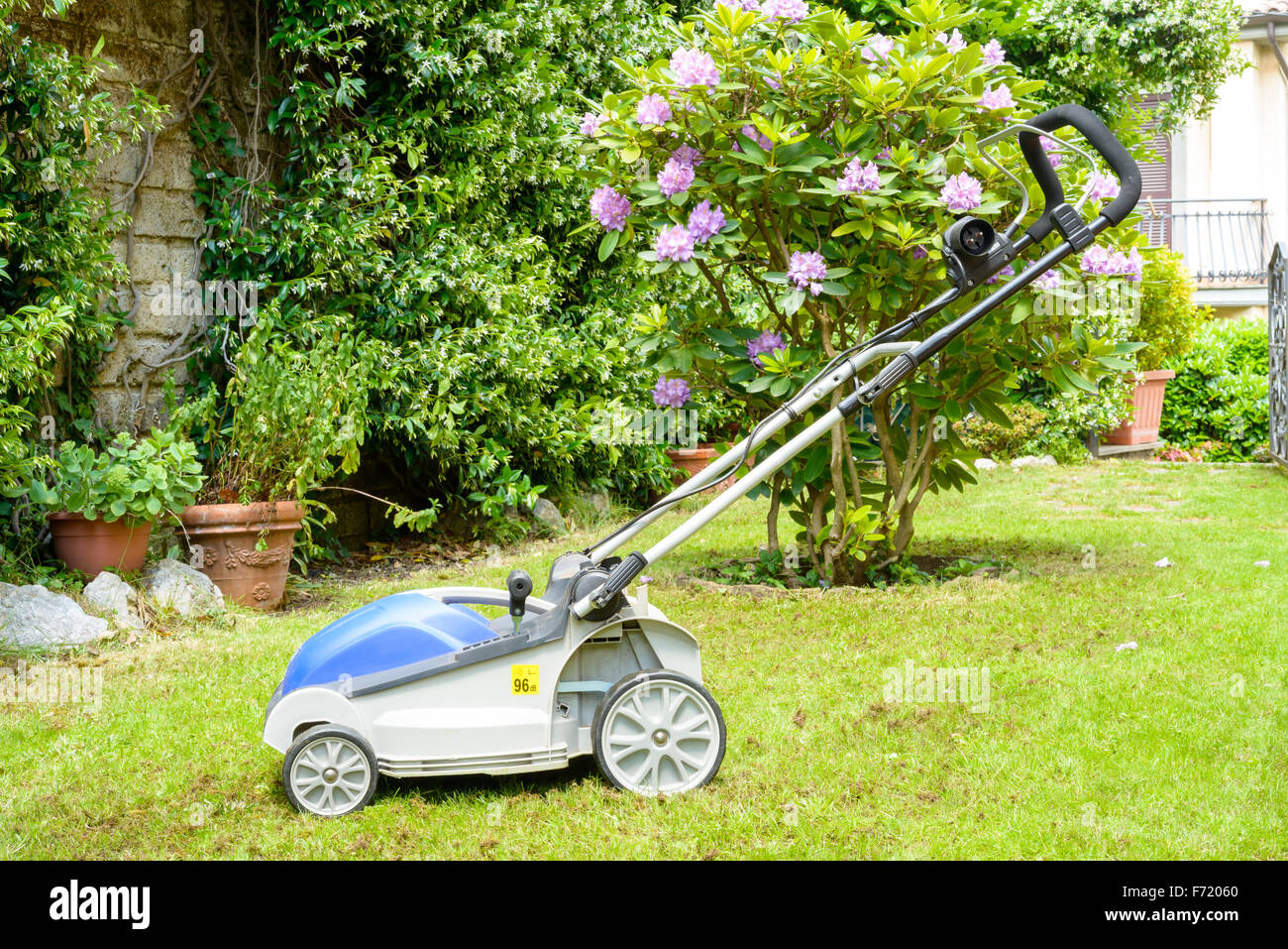 Blue Lawnmower in a garden during the work Stock Photo - Alamy