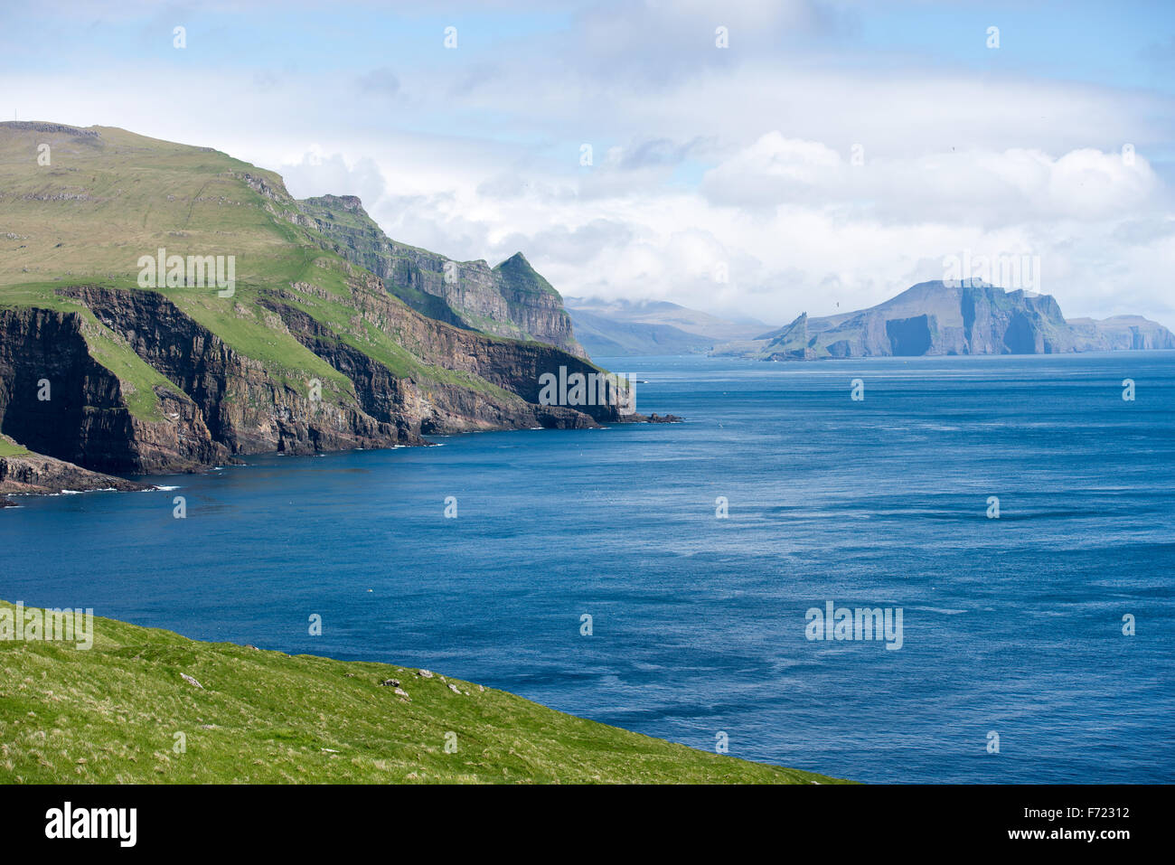Typical landscape on the Faroe Islands, with green grass, water and ...