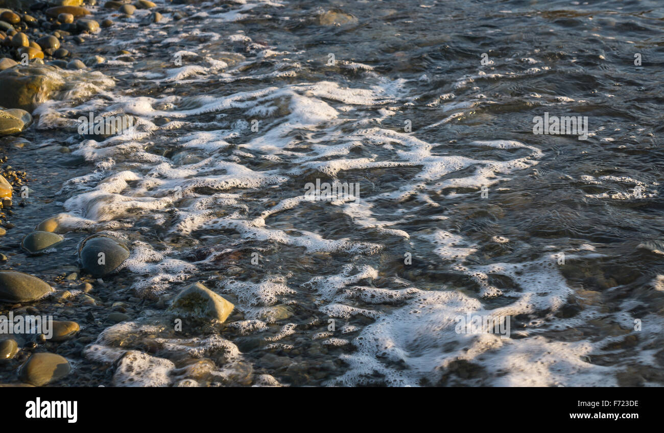 Gentle waves on pebble sea shore Stock Photo - Alamy