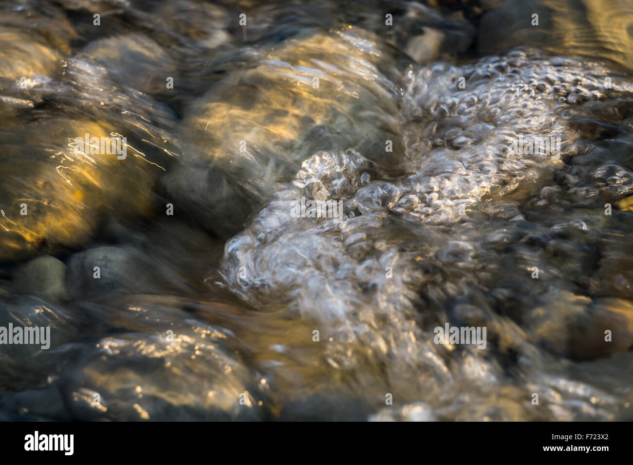 Close up of clear stream flowing over pebbles Stock Photo - Alamy