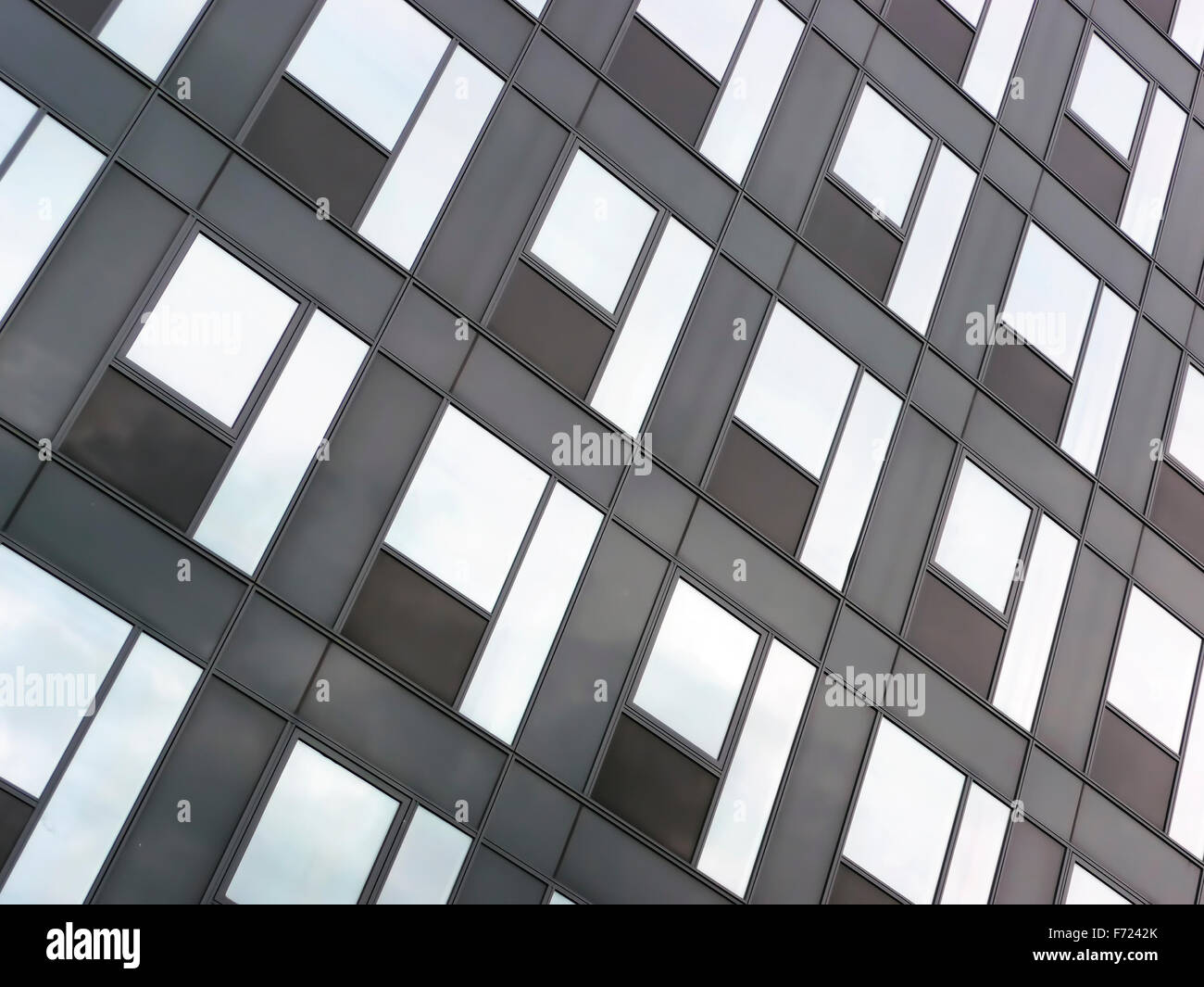 Modern black glass facade reflecting blue sky with clouds Stock Photo ...