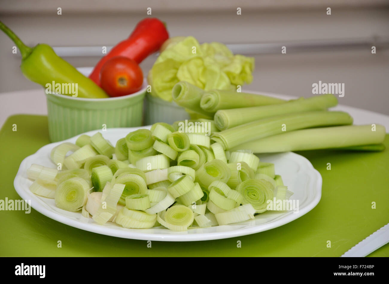 Leek rings on a plate with other different vegetables in background ...