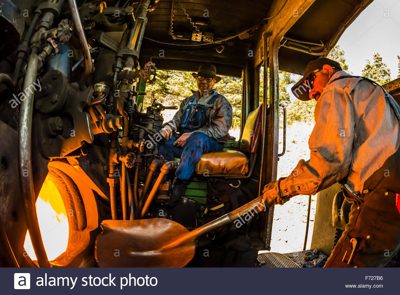 The fireman stokes the fire in the boiler of the steam engine Stock ...