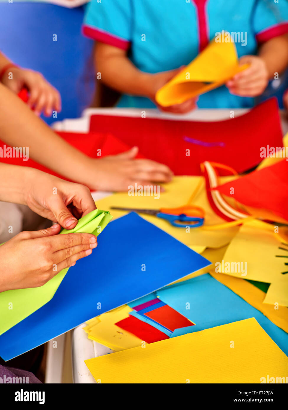 Kids holding colored paper on table in kindergarten Stock Photo - Alamy