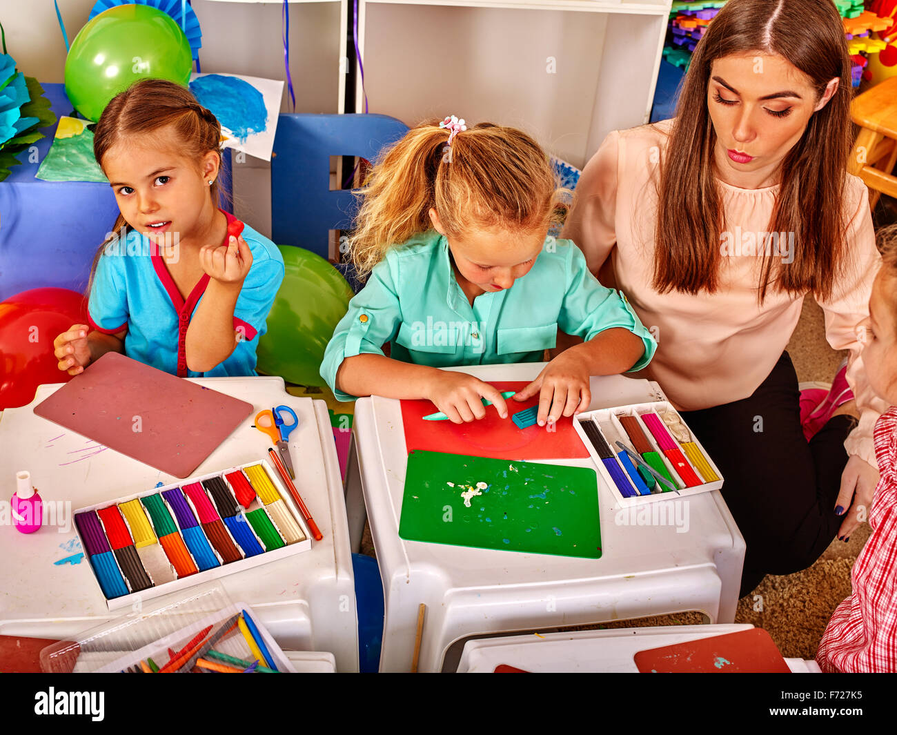 Kids holding colored paper on table in kindergarten Stock Photo - Alamy