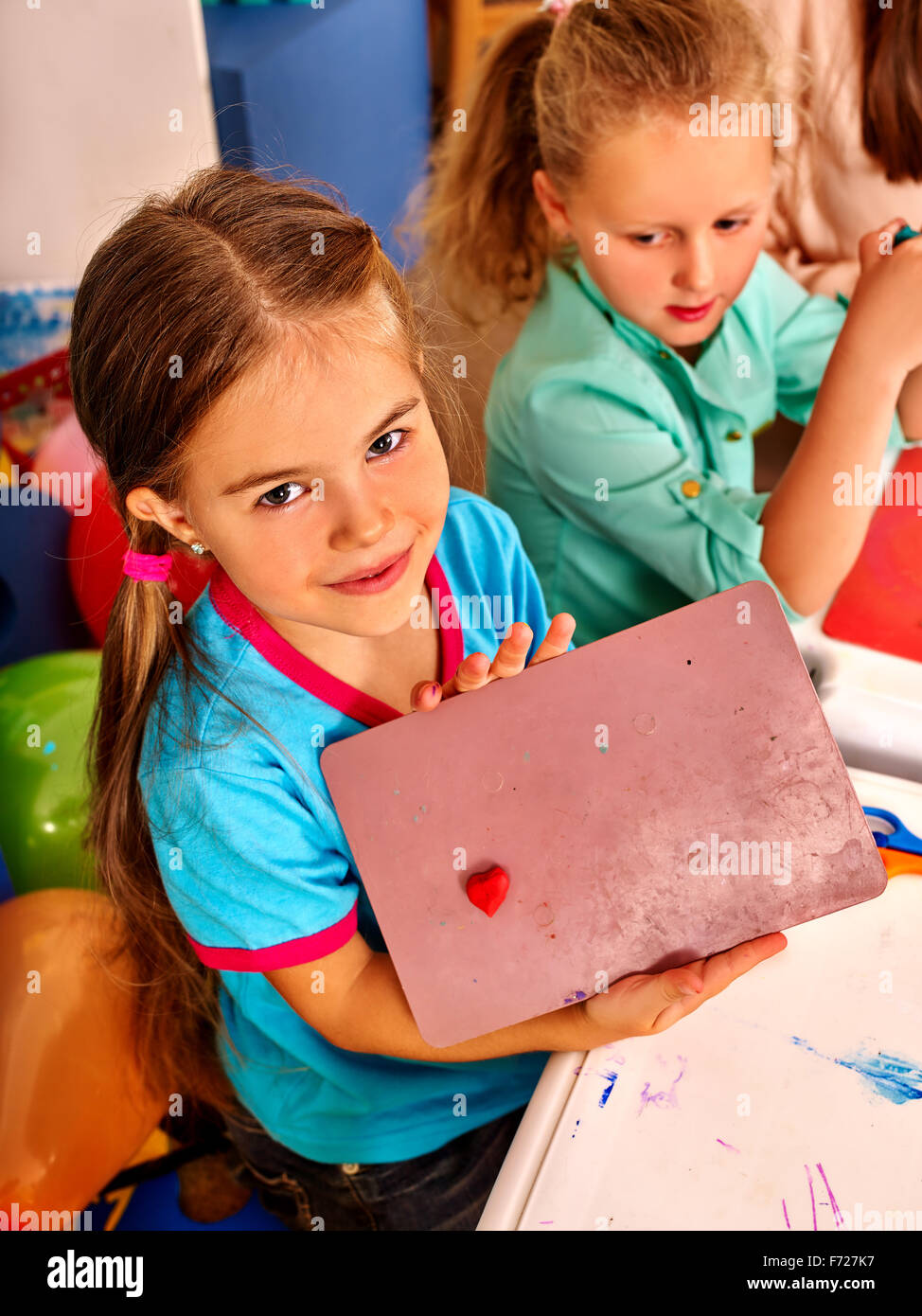 Kids holding colored paper on table in kindergarten Stock Photo - Alamy