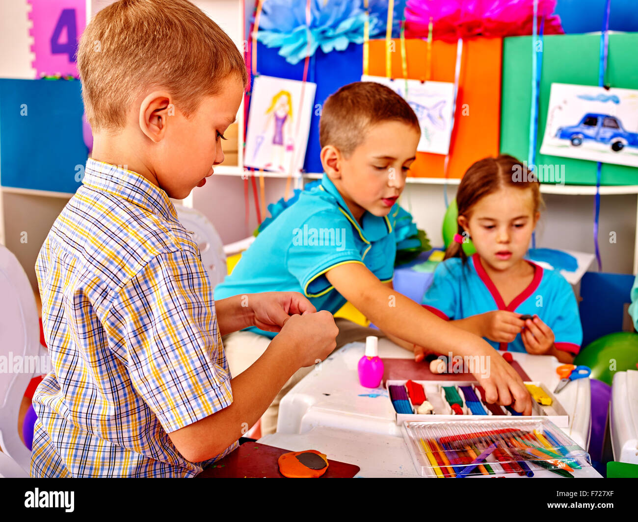 Kids holding colored paper on table in kindergarten Stock Photo - Alamy