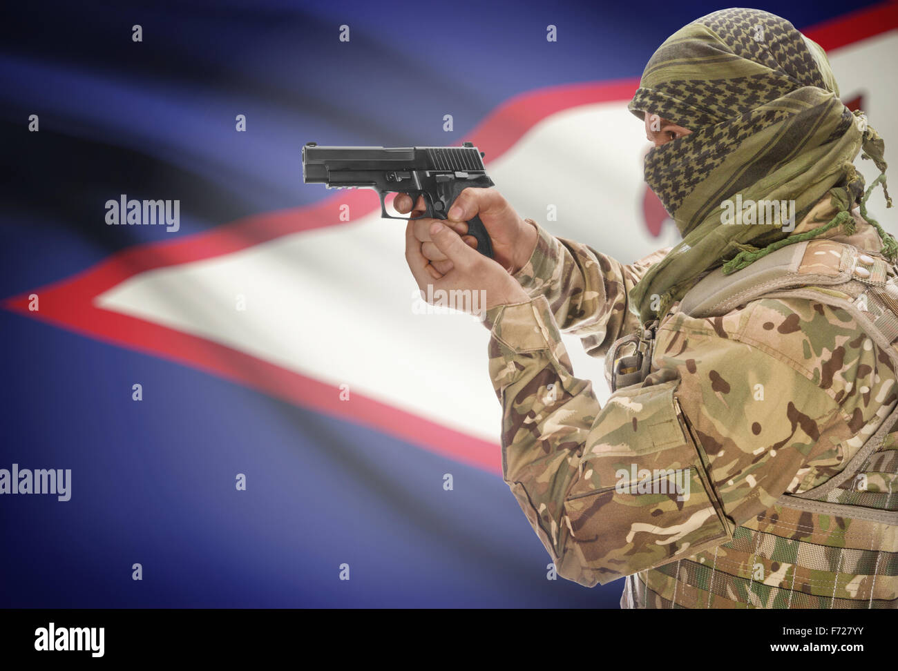 Male in muslim keffiyeh with gun in hand and national flag on ...