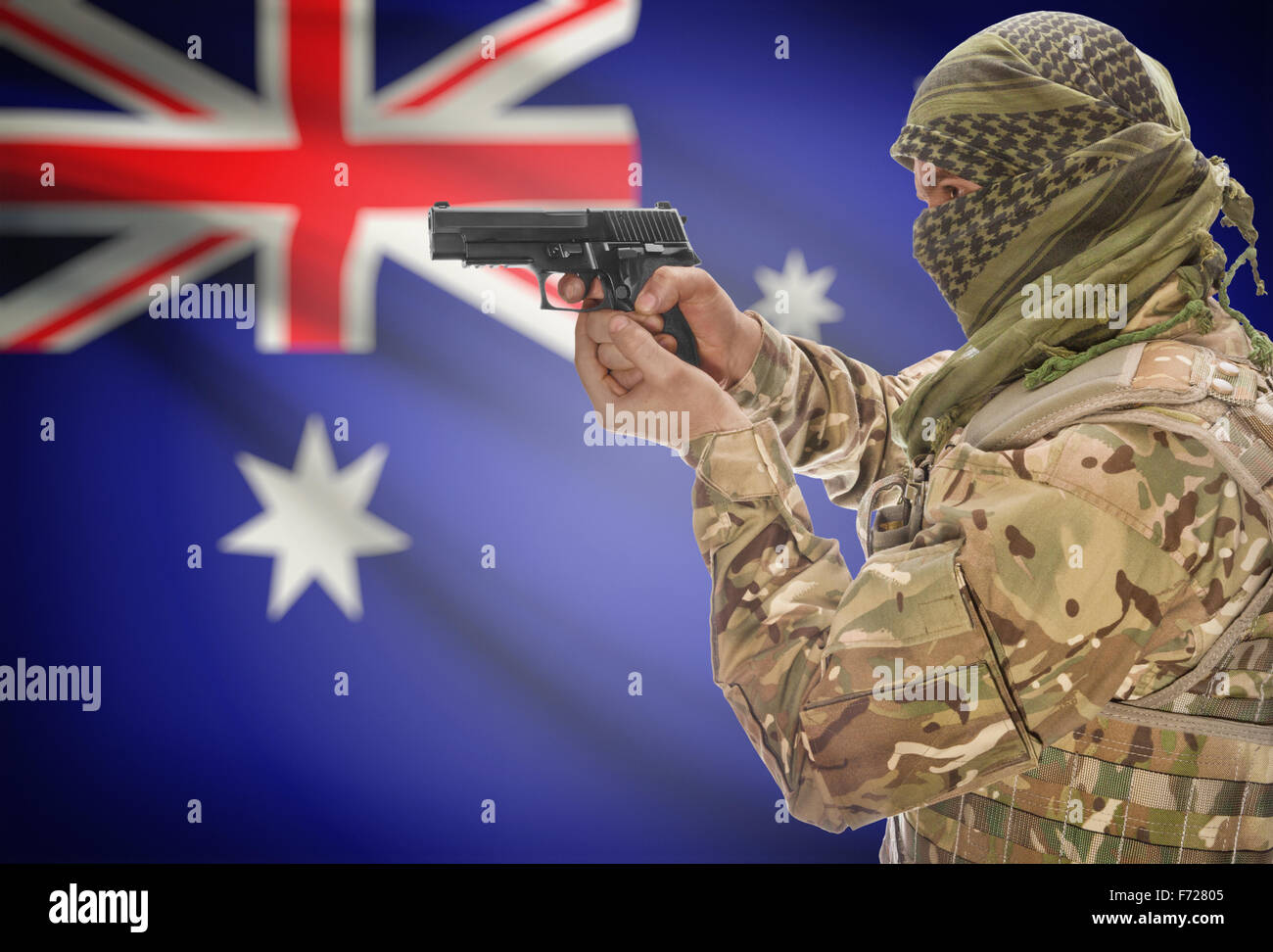 Male in muslim keffiyeh with gun in hand and national flag on ...