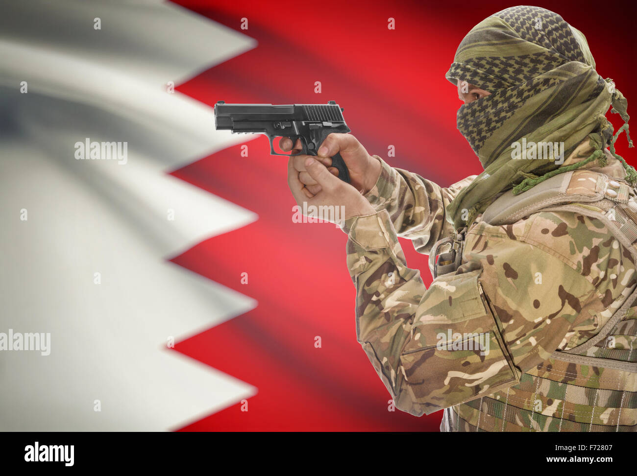 Male in muslim keffiyeh with gun in hand and national flag on ...
