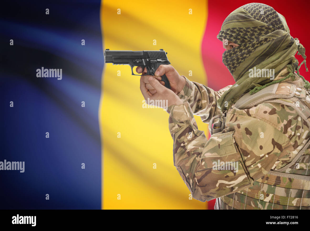 Male in muslim keffiyeh with gun in hand and national flag on ...