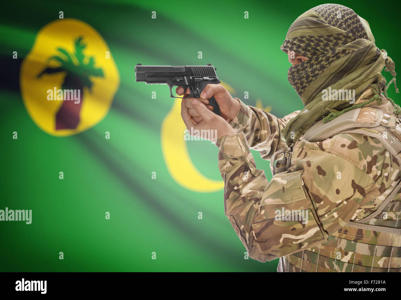 Male in muslim keffiyeh with gun in hand and national flag on ...