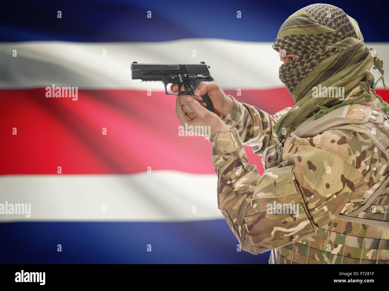 Male in muslim keffiyeh with gun in hand and national flag on ...