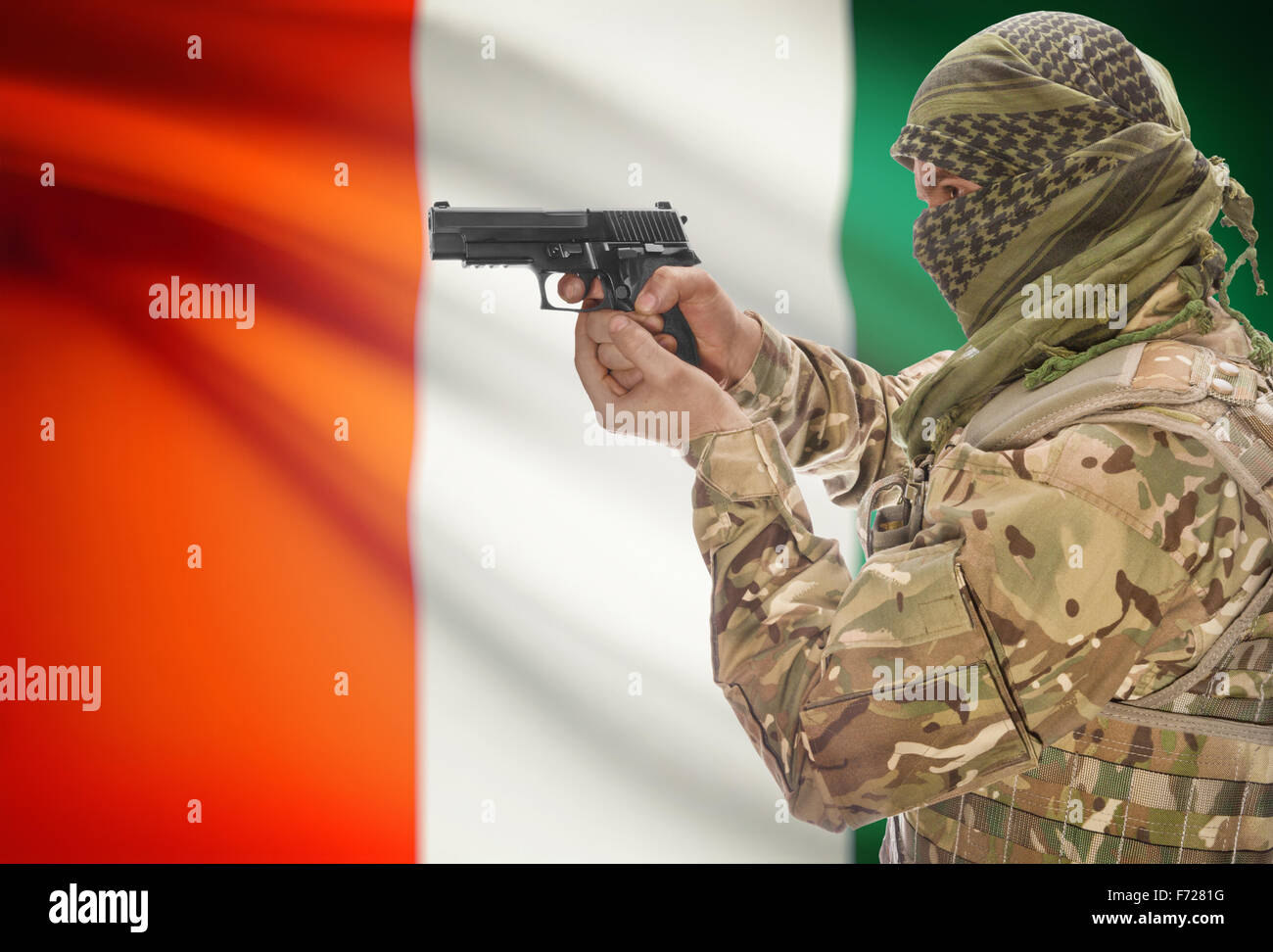 Male in muslim keffiyeh with gun in hand and national flag on ...
