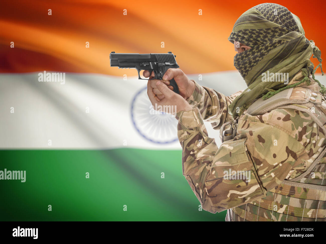 Male in muslim keffiyeh with gun in hand and national flag on ...