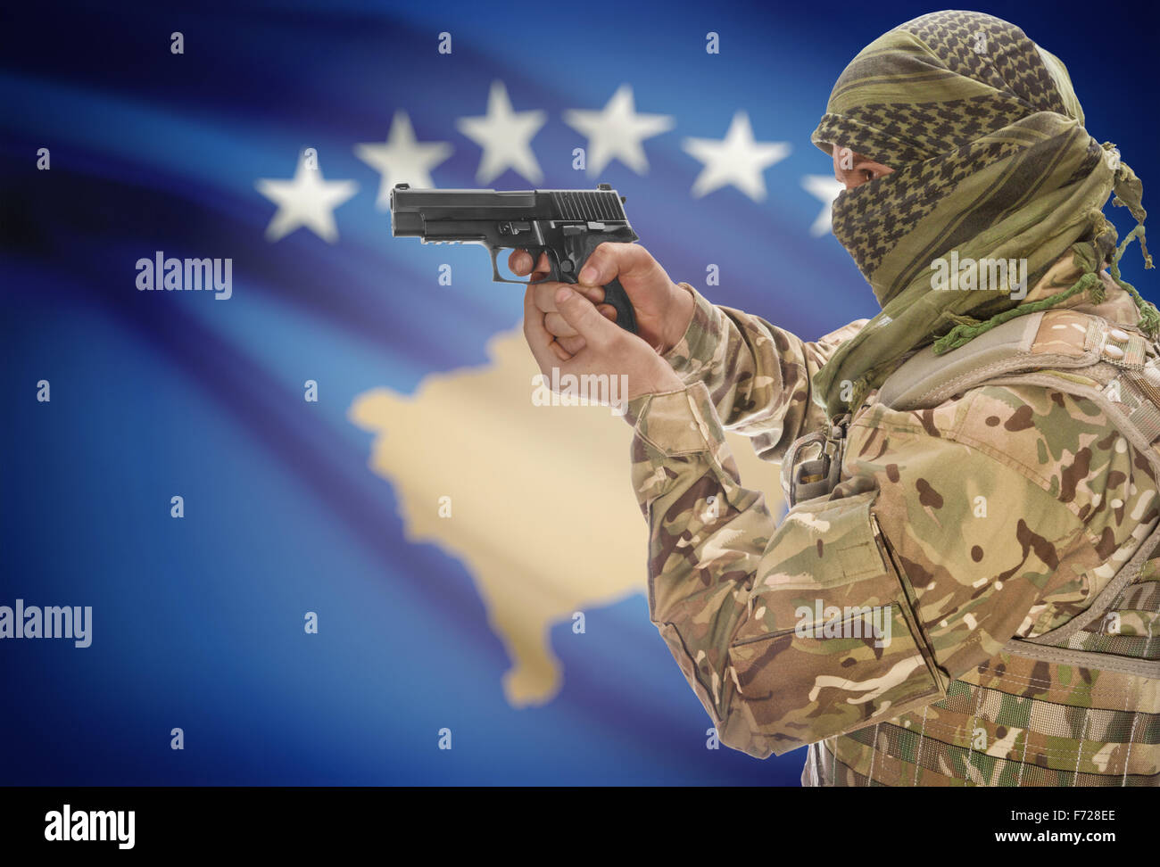 Male in muslim keffiyeh with gun in hand and national flag on ...