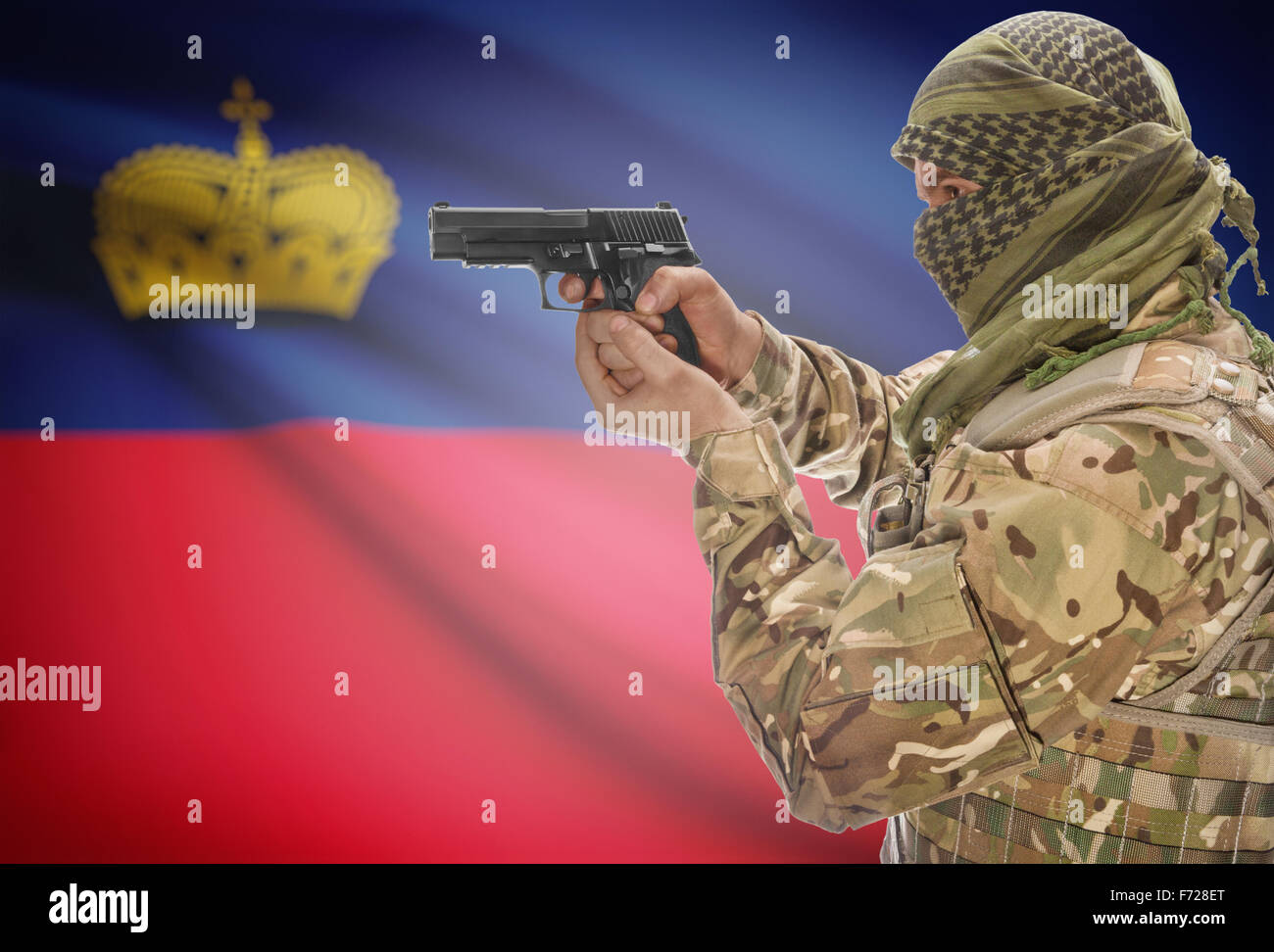 Male in muslim keffiyeh with gun in hand and national flag on ...