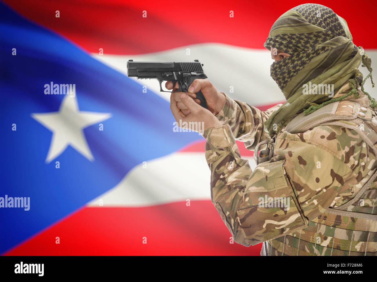 Male in muslim keffiyeh with gun in hand and national flag on ...