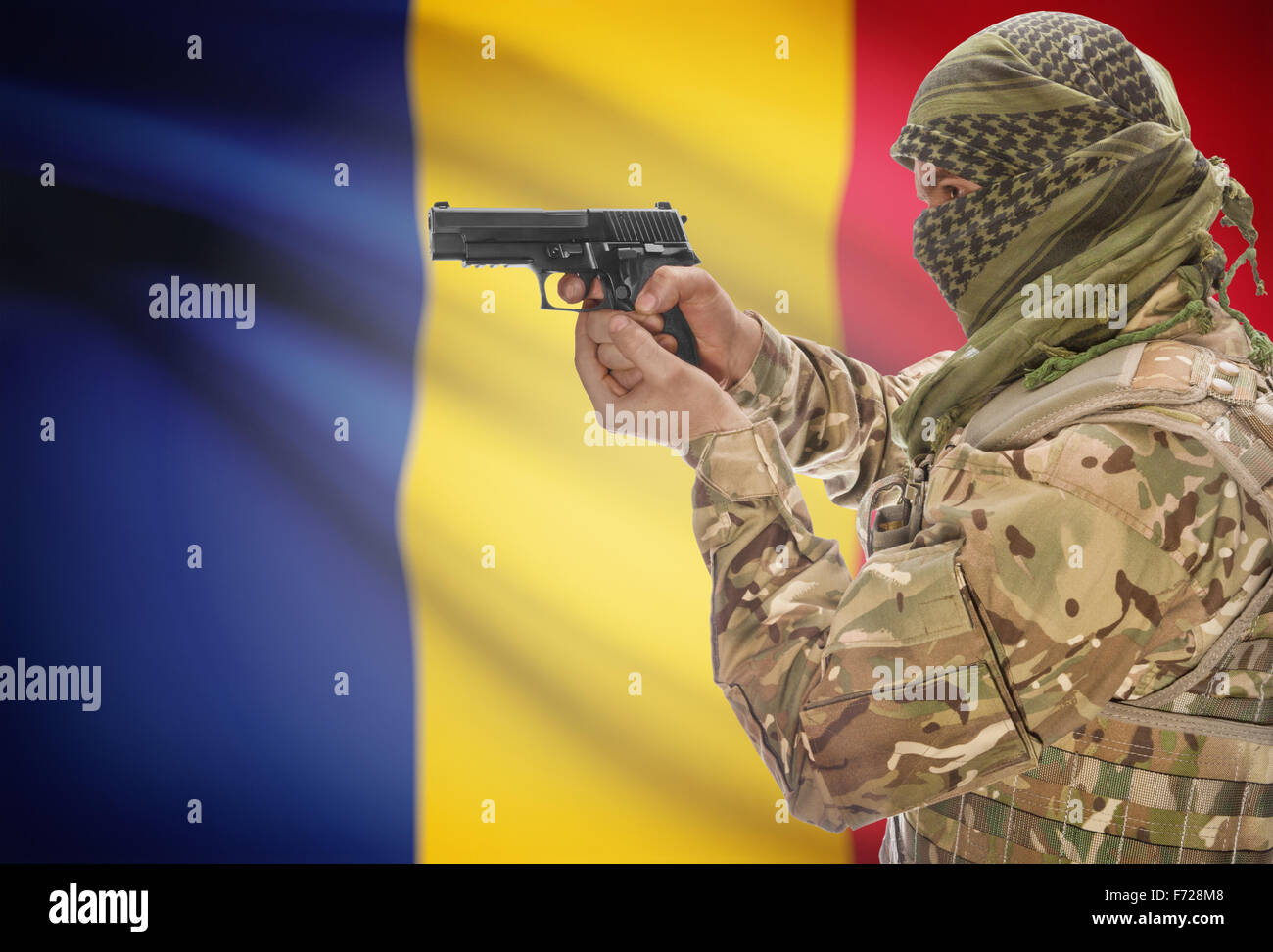 Male in muslim keffiyeh with gun in hand and national flag on ...