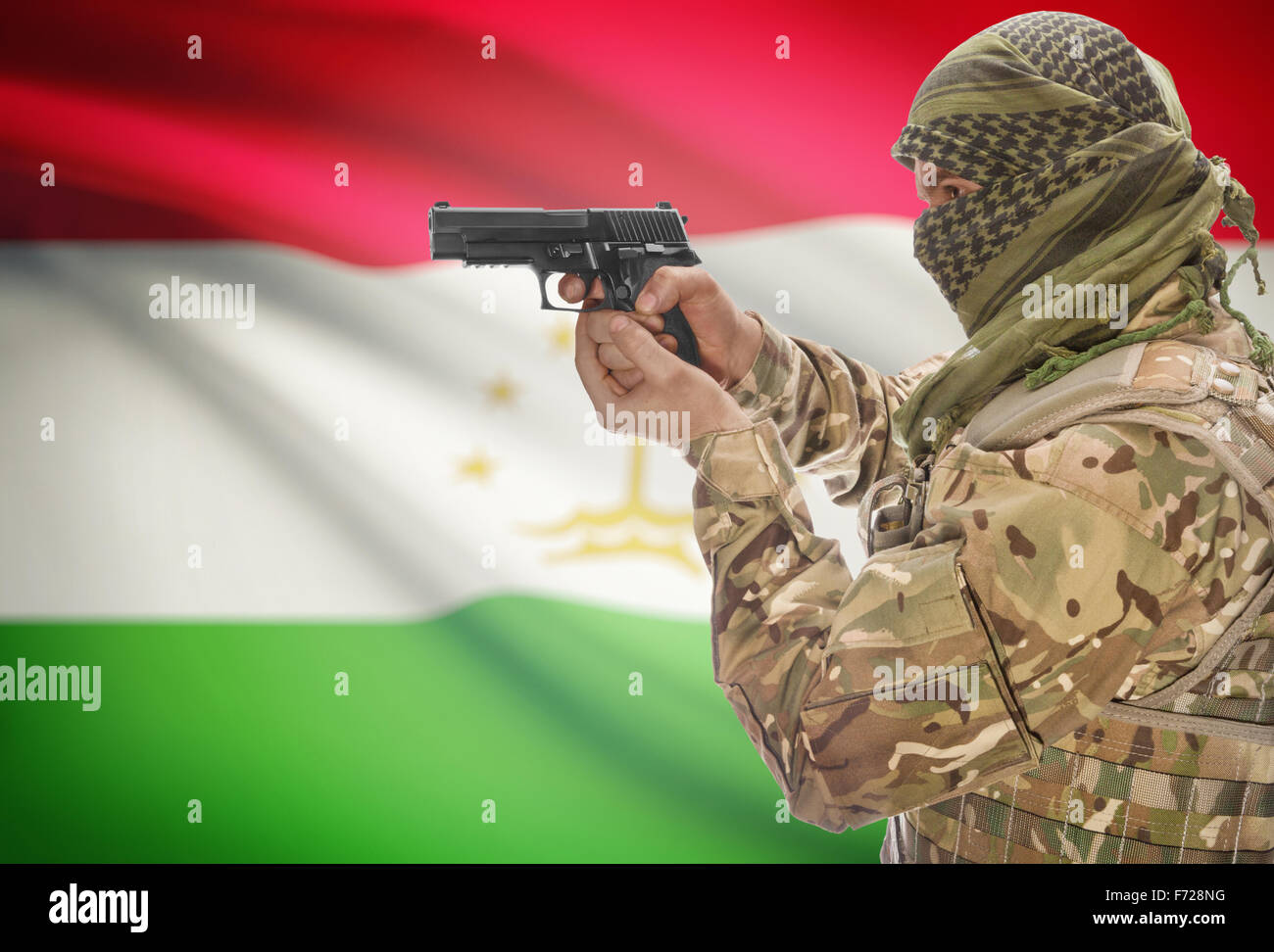 Male in muslim keffiyeh with gun in hand and national flag on ...