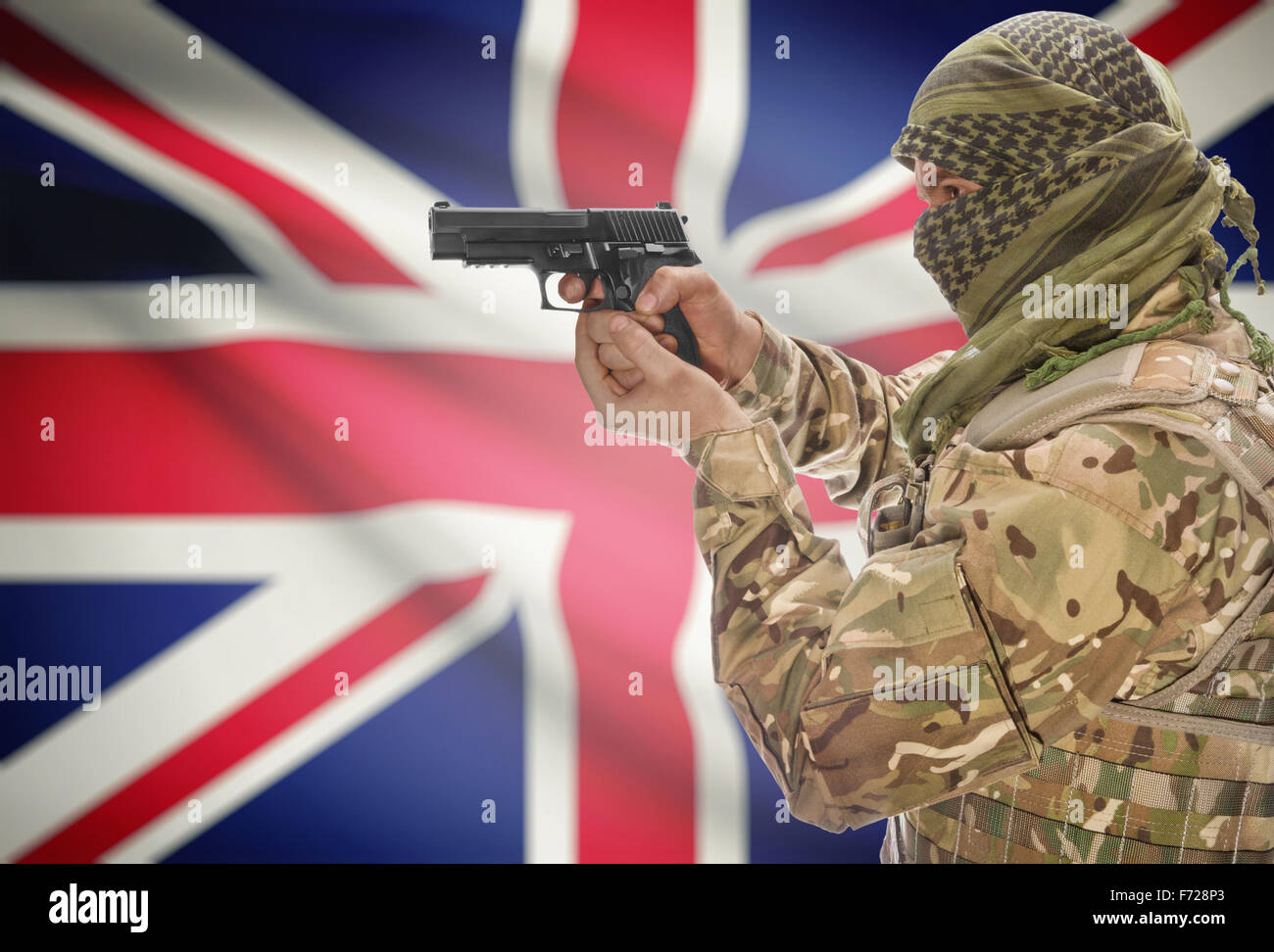 Male in muslim keffiyeh with gun in hand and national flag on ...