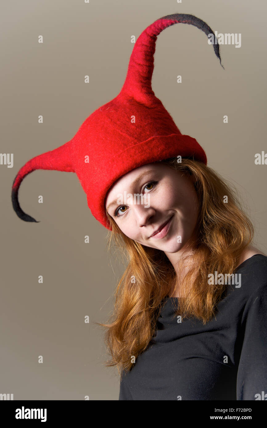 Cheeky redhead in funny red felt hat Stock Photo - Alamy