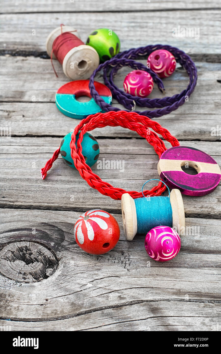 Stylish beads and spools of thread on wooden background Stock Photo - Alamy