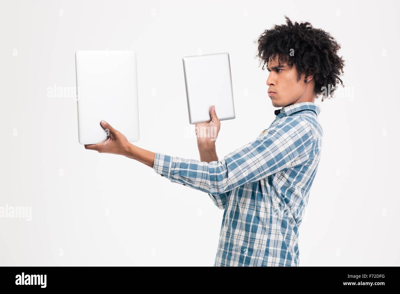 Portrait of a young afro american man choosing between tablet computer ...