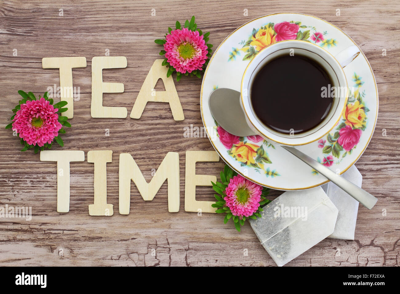 Tea time written with wooden letters, tea in vintage cup, tea bags and ...
