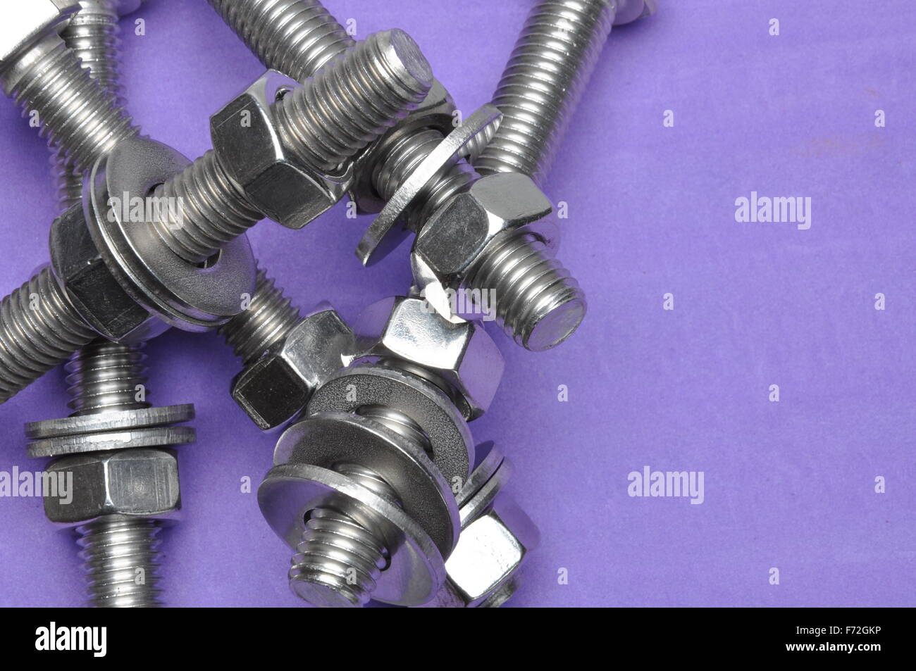 Bolts and nuts on violet background Stock Photo - Alamy