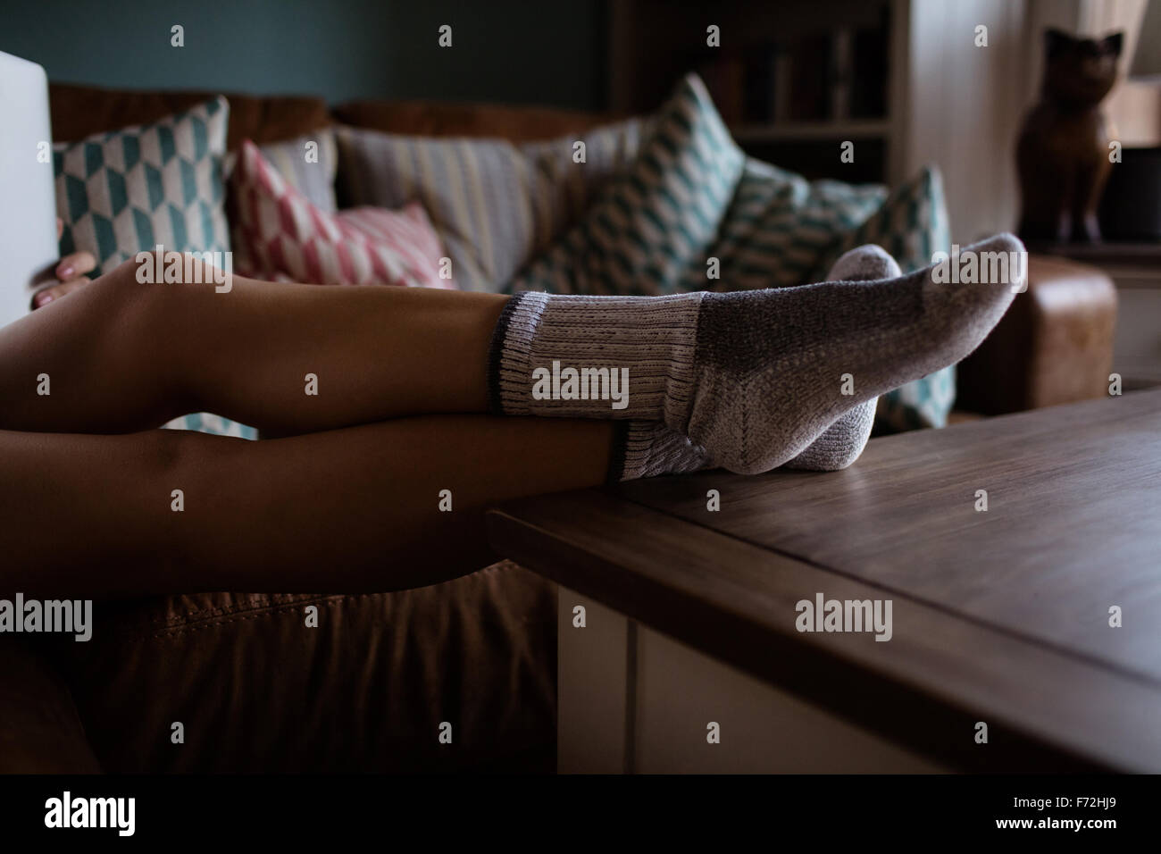Womans legs crossed on wooden table Stock Photo - Alamy