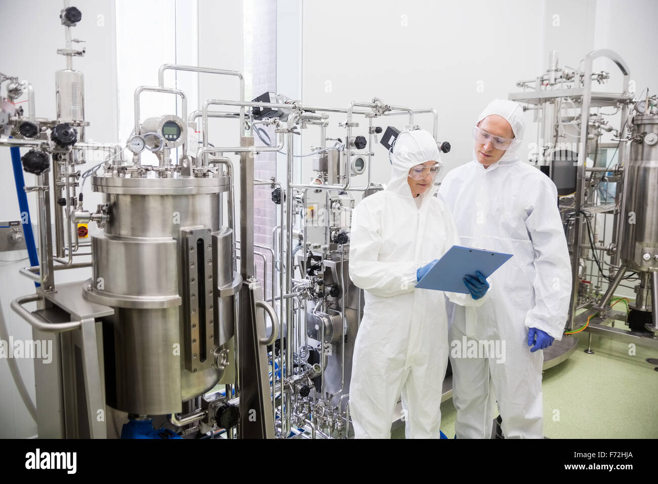 Scientists working with large vat Stock Photo - Alamy