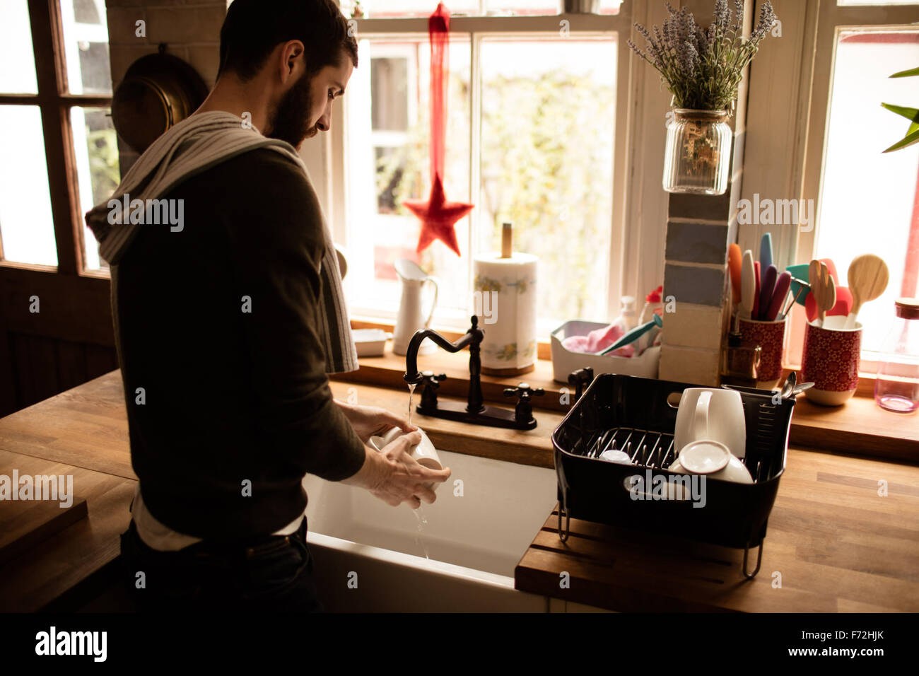 Man washing his cup in kitchen Stock Photo - Alamy