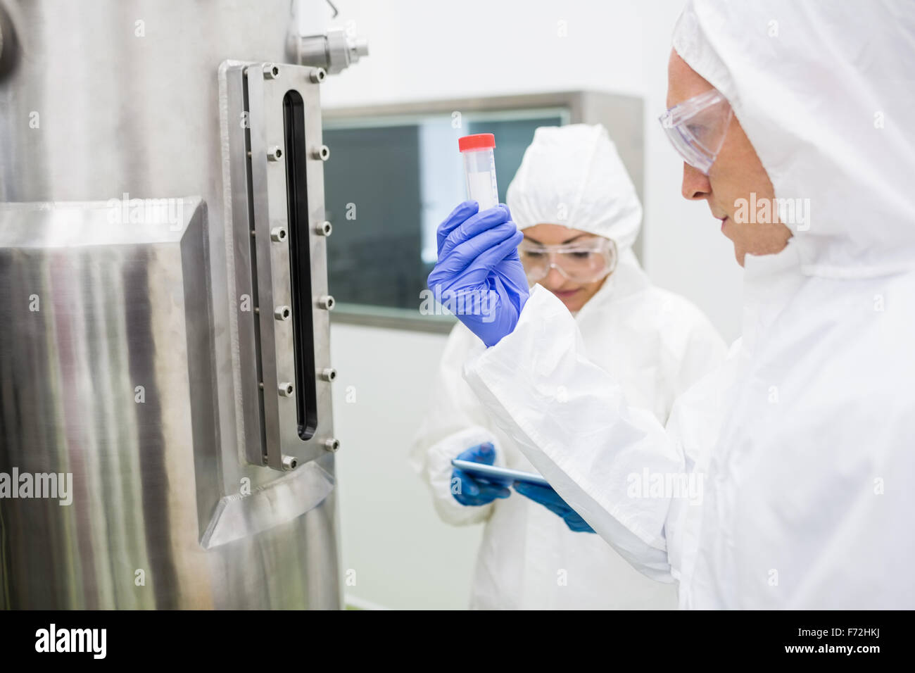 Scientists working with large vat Stock Photo - Alamy