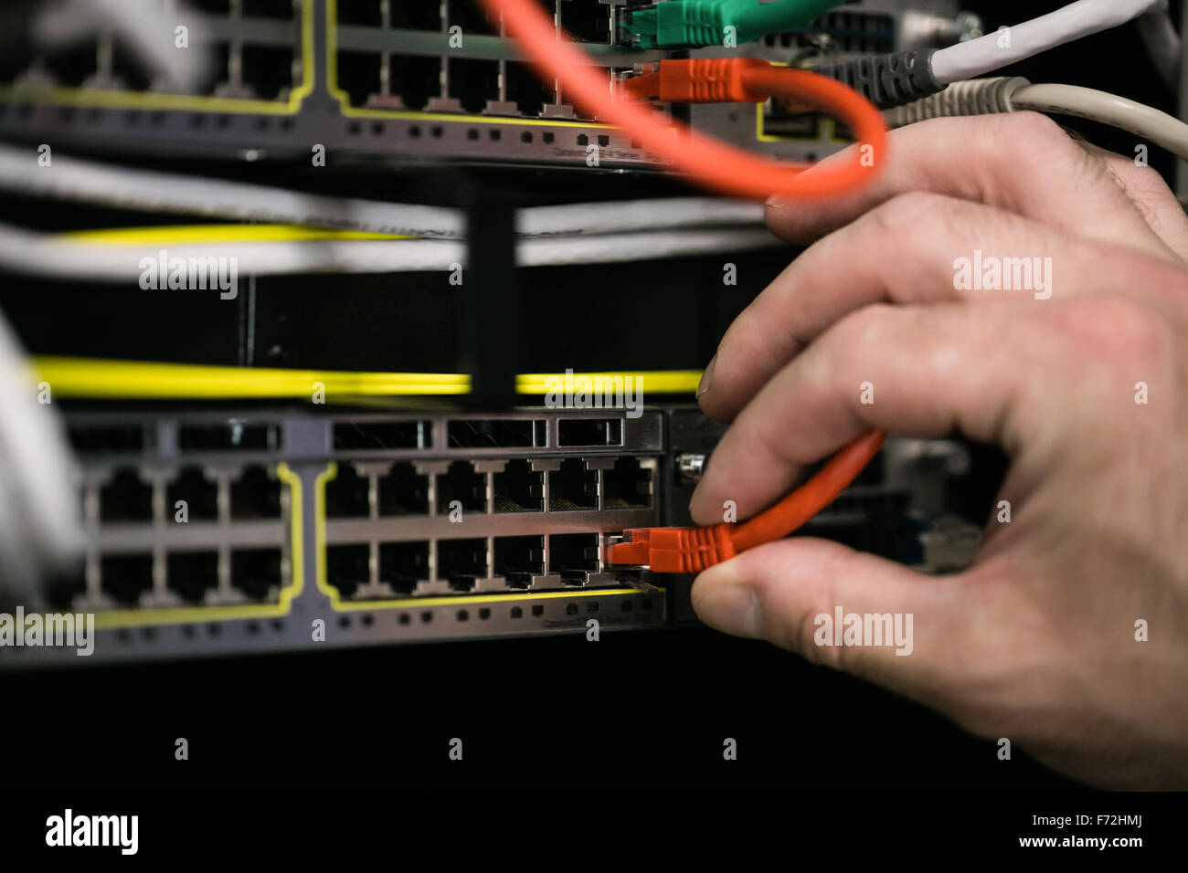 Technician inserting wire to server Stock Photo - Alamy