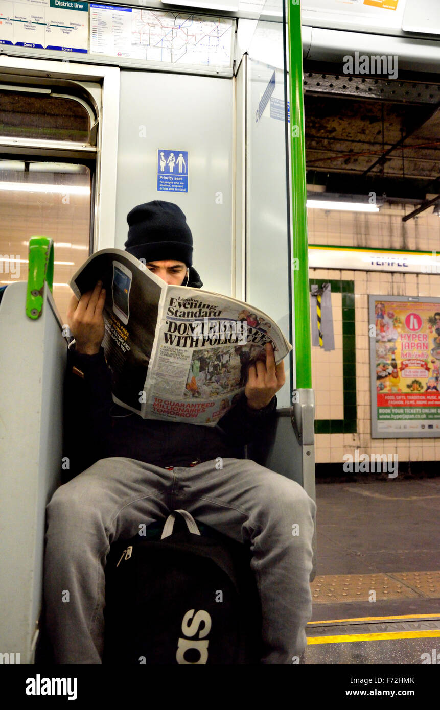 London, England, UK. Man reading a newspaper on a tube train (in a ...