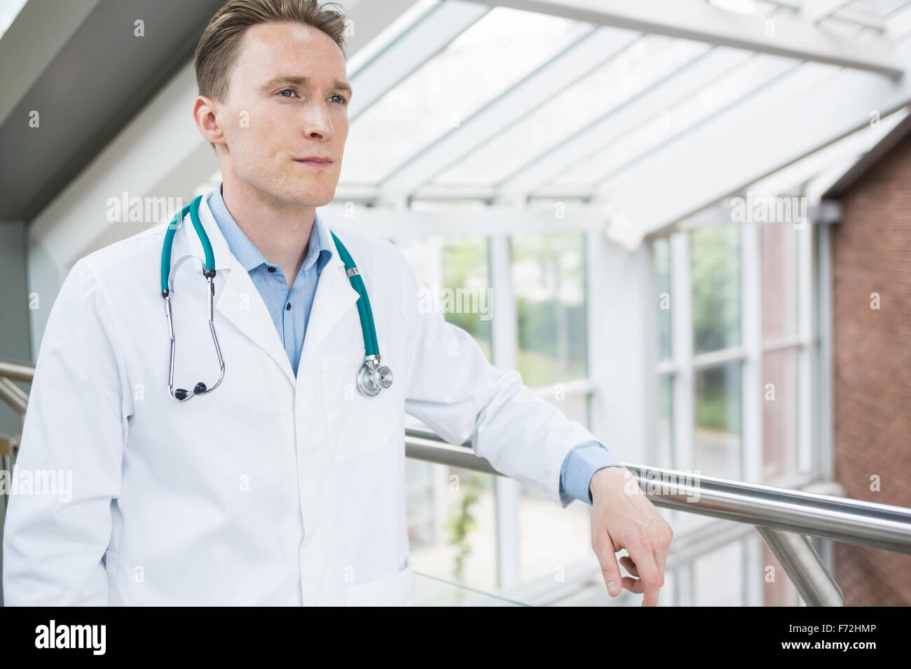 Young doctor standing and thinking Stock Photo - Alamy