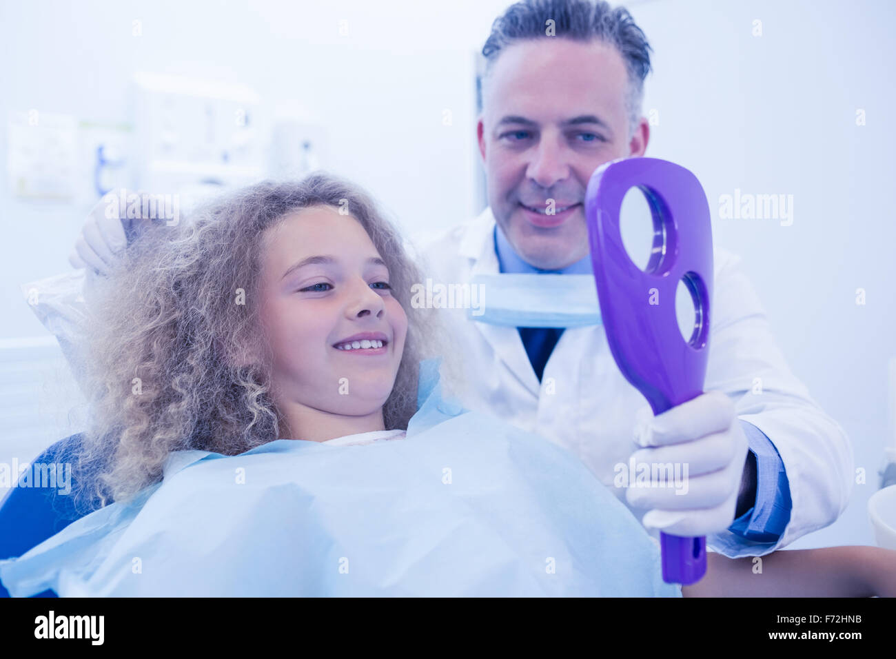 Pediatric dentist showing patient new smile Stock Photo - Alamy