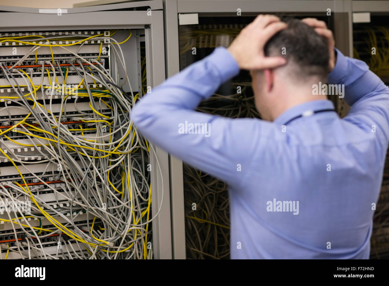 Stressed technician looking at open server locker Stock Photo - Alamy