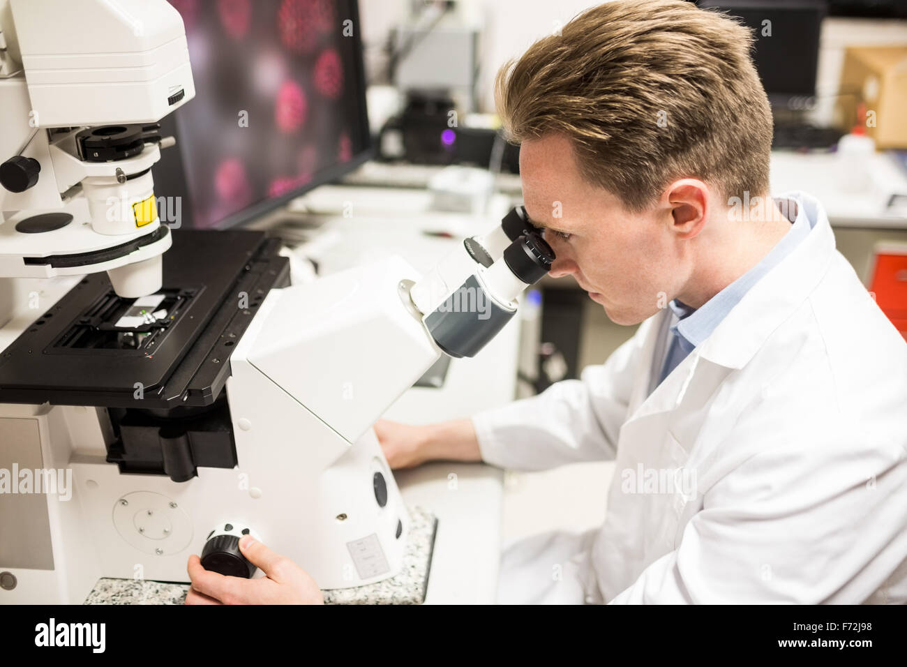 Scientist looking through a microscope Stock Photo - Alamy