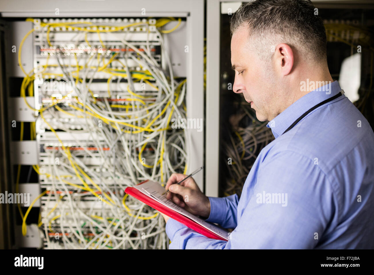 Stressed technician looking at open server locker Stock Photo - Alamy