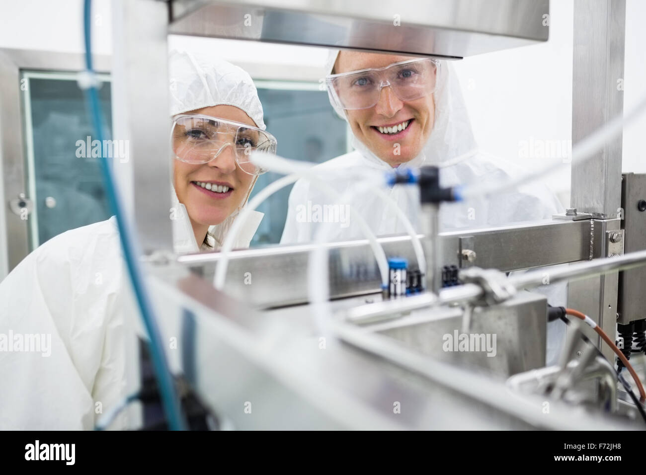 Scientists working with large vat Stock Photo - Alamy