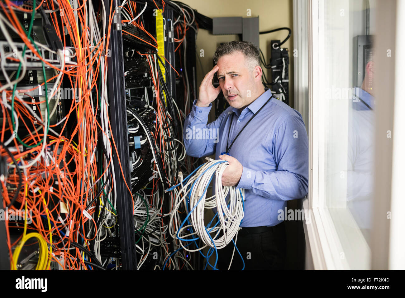 Stressed technician looking at open server locker Stock Photo - Alamy
