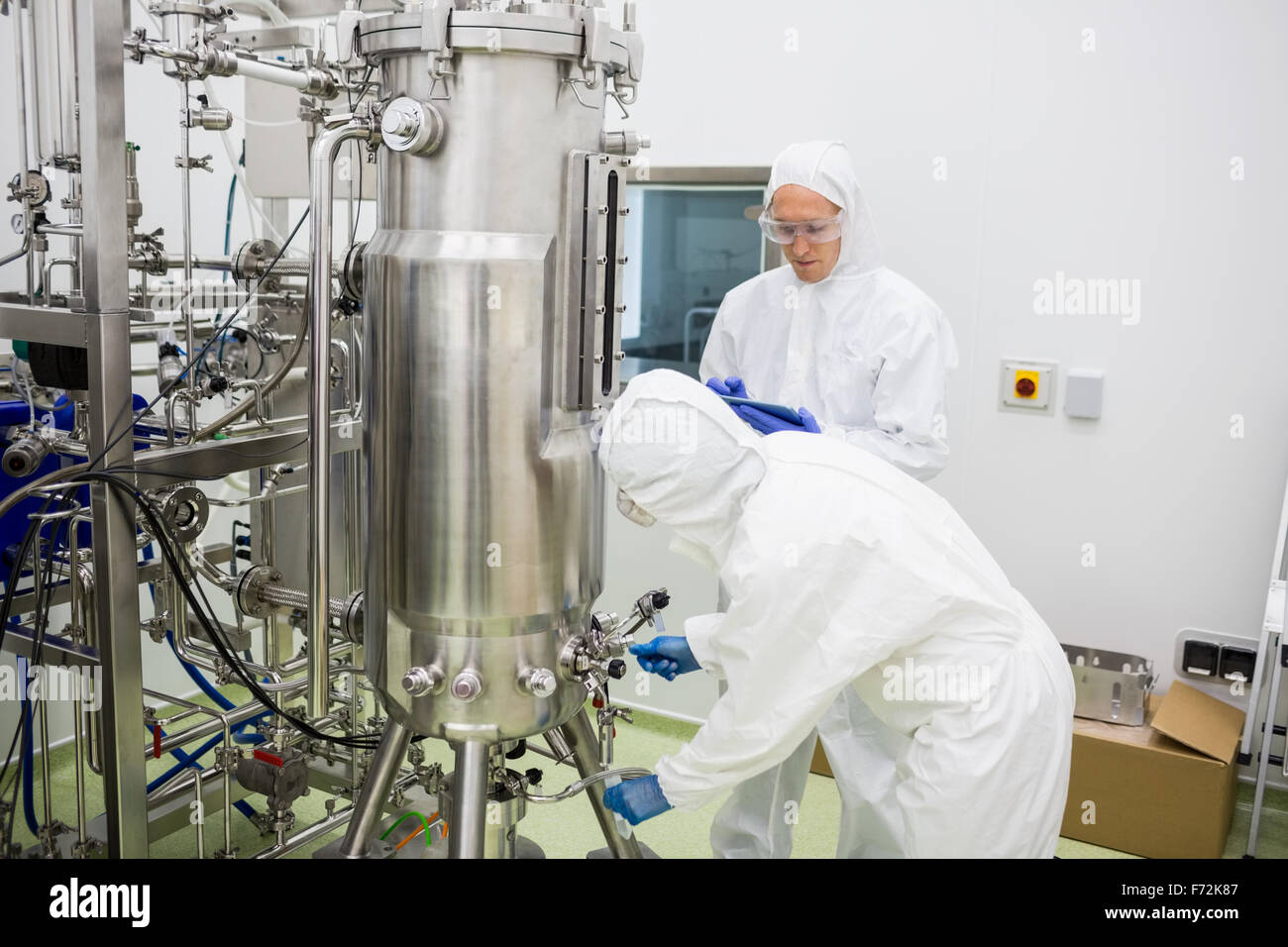 Scientists working with large vat Stock Photo - Alamy