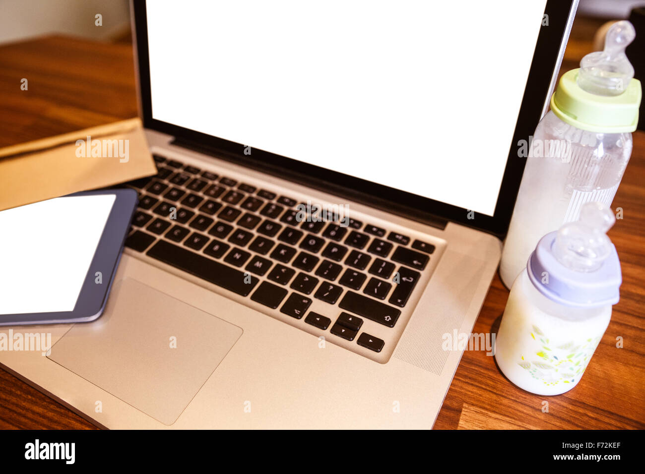 Table with feeding bottles laptop and tablet Stock Photo - Alamy