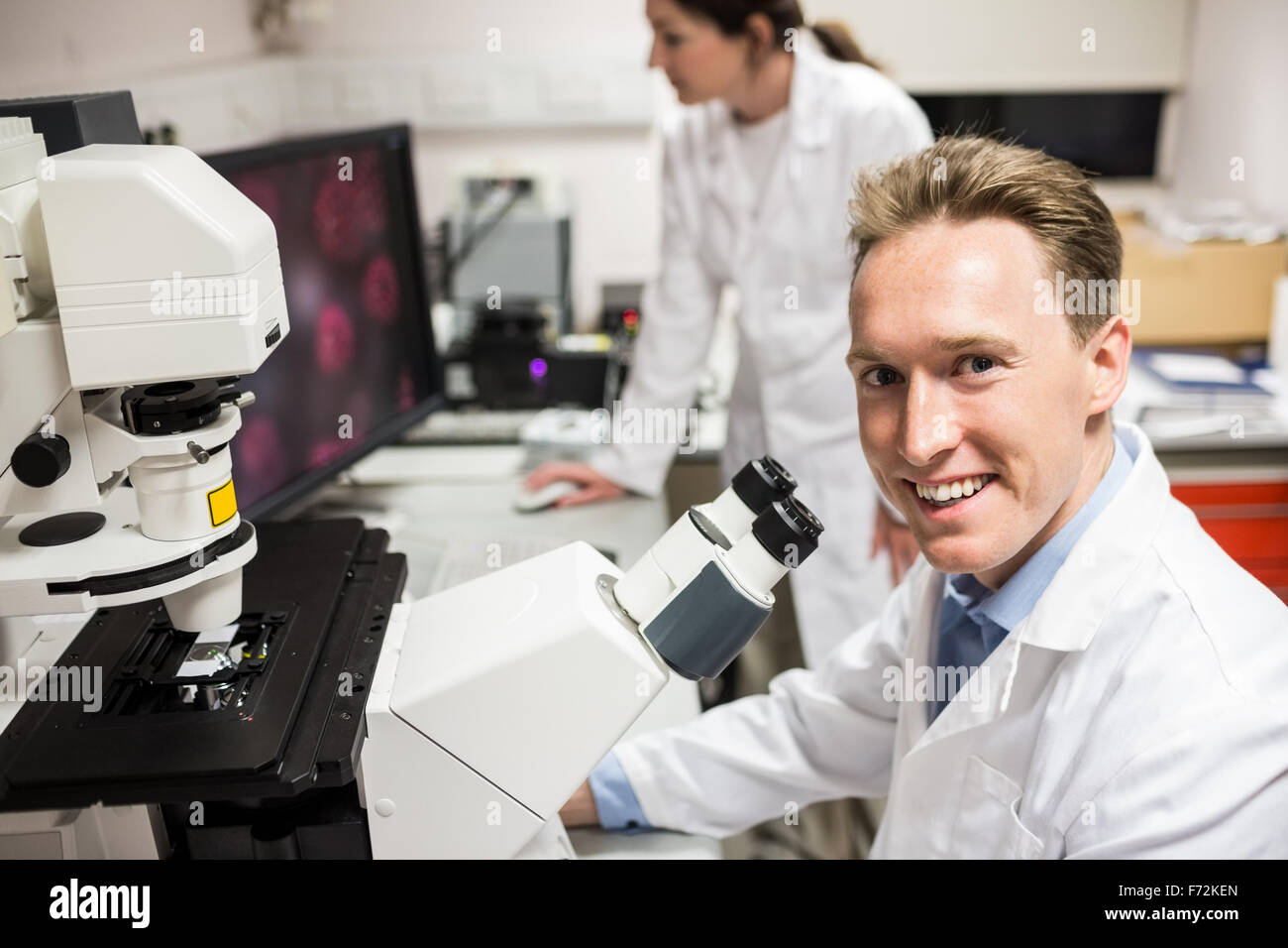 Smiling woman with a microscope hi-res stock photography and images - Alamy