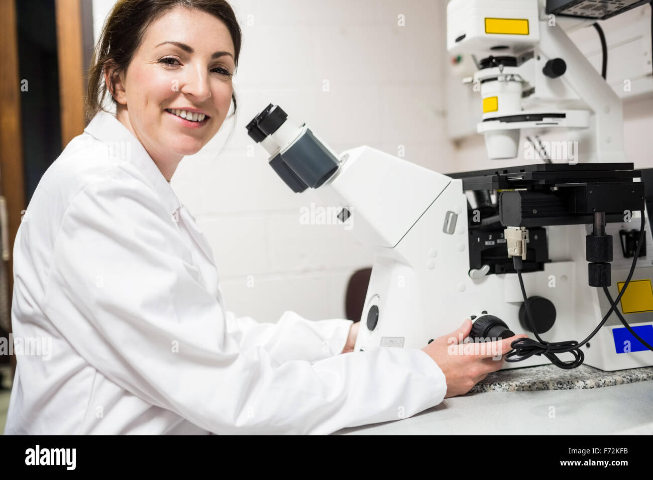 Scientist looking through a microscope Stock Photo - Alamy