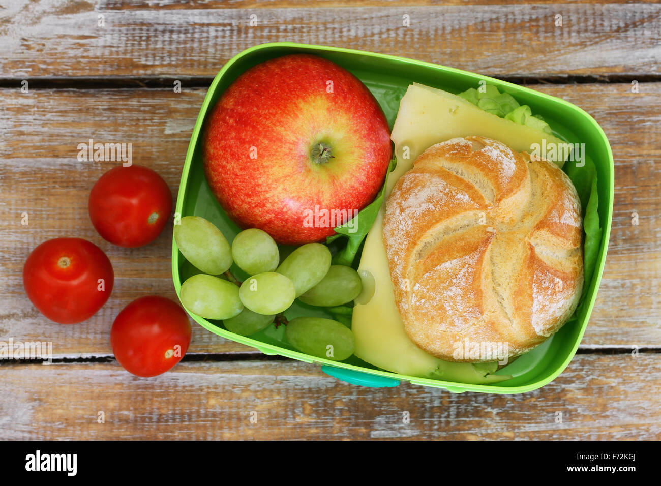 School lunch box with cheese sandwich, red apple, grapes and cherry ...
