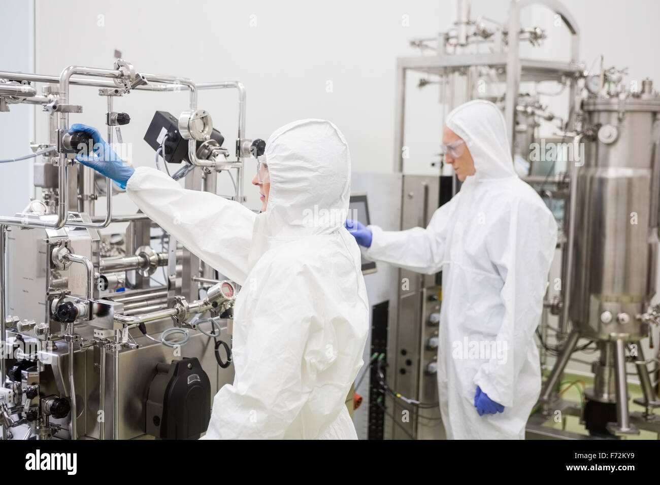 Scientists working with large vat Stock Photo - Alamy